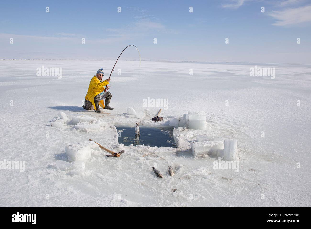 Fishing on frozen lake Stock Photo - Alamy
