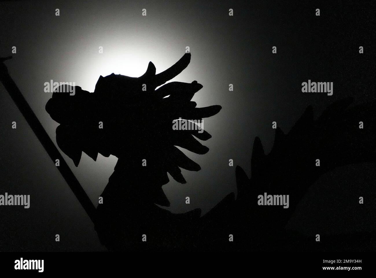 A naga statue is silhouetted against the moon during a total lunar ...