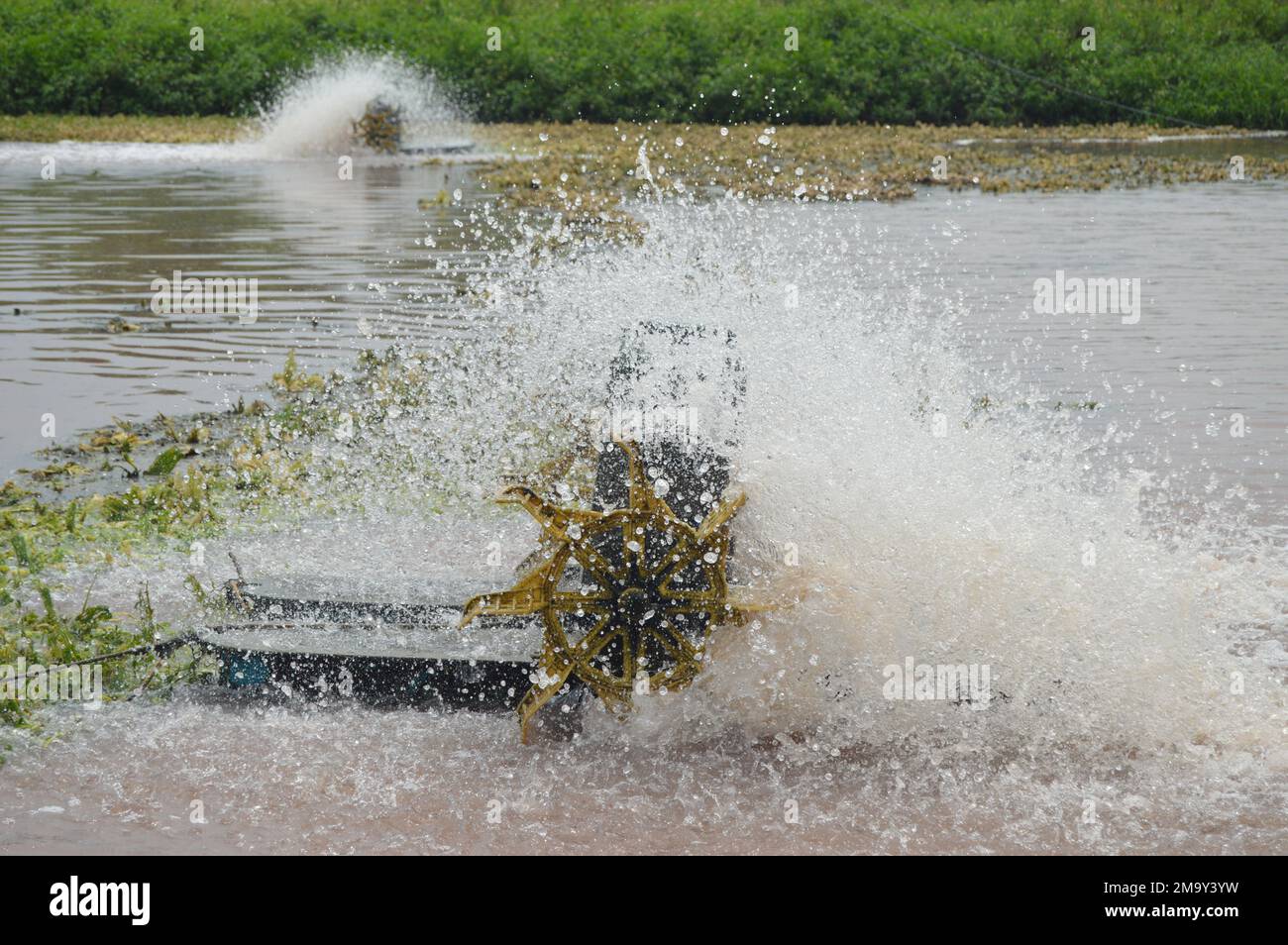 The waterwheel stirs the surface of the water in a sewage treatment ...