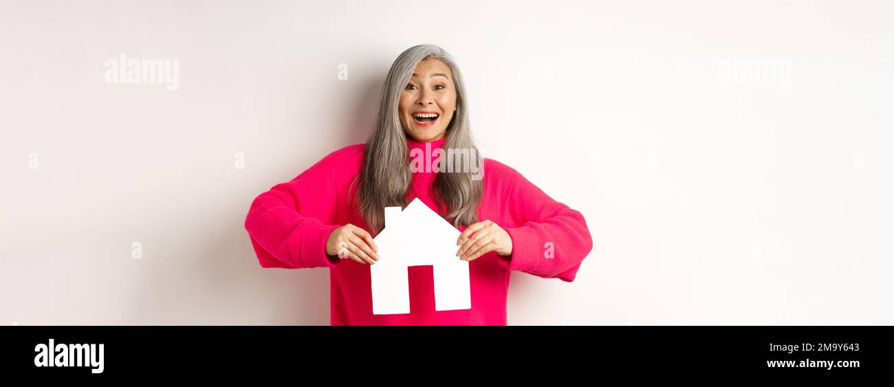 Real estate. Excited asian senior woman looking happy and lucky ...