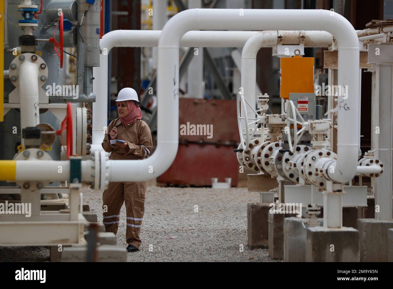 A woman works at a gas facility in Homs province, Syria, Wednesday, Nov ...