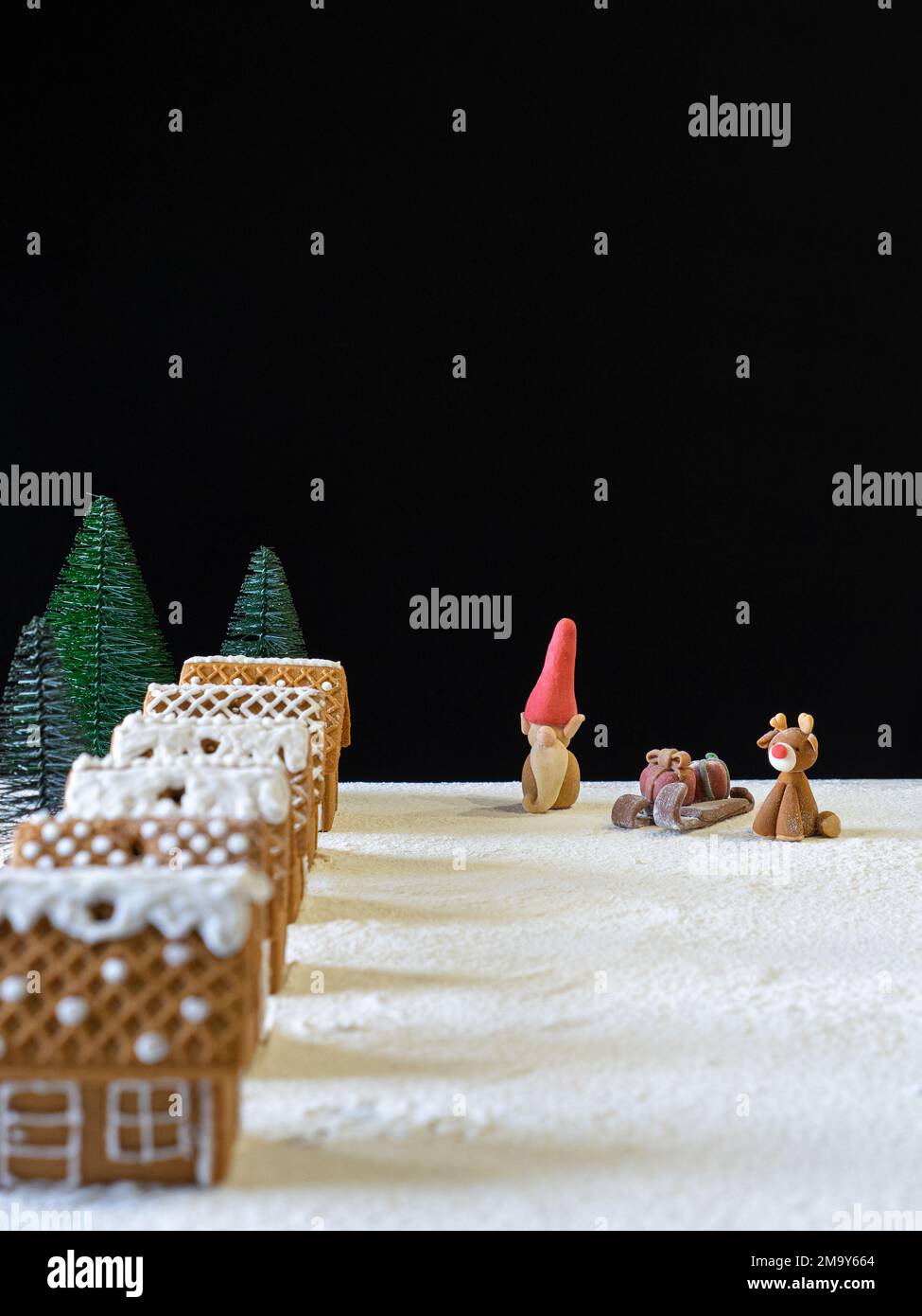 A line of gingerbread houses with a gnome, a moose and a sleigh with ...
