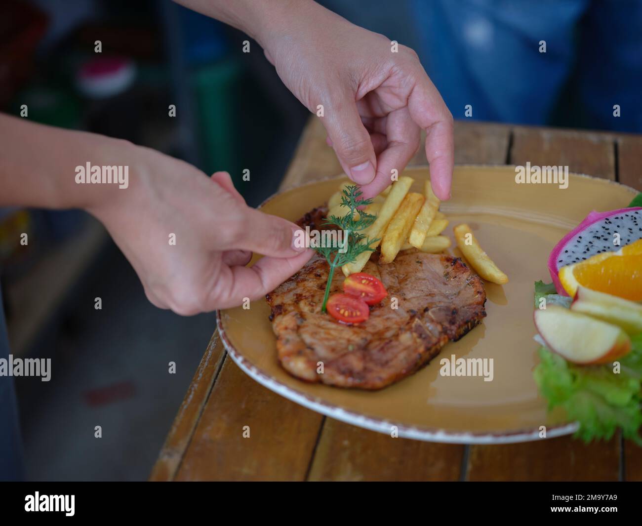 Chefs hand prepares a Grilled pork ribs and decorates hearb Stock Photo ...