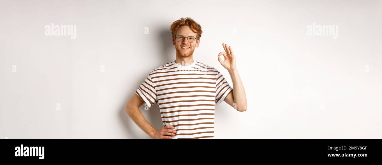 Confident smiling man with red hair assuring you, showing OK sign ...