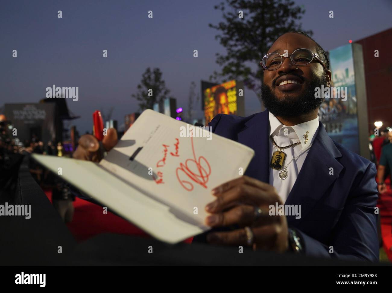 Director Ryan Coogler signs autographs on the red carpet at the ...