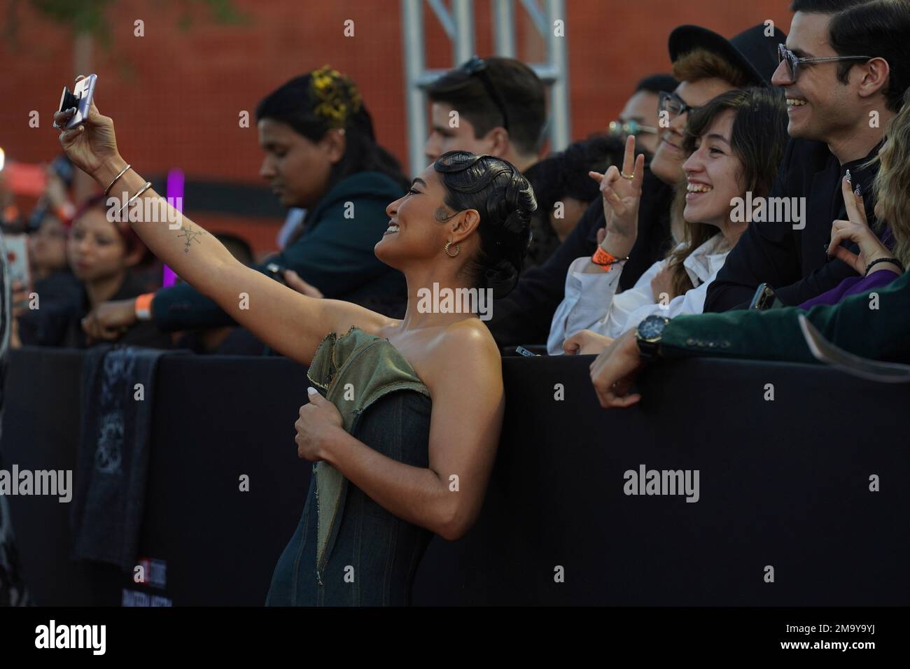 Mabel Cadena takes a selfie with fans on the red carpet at the premiere ...