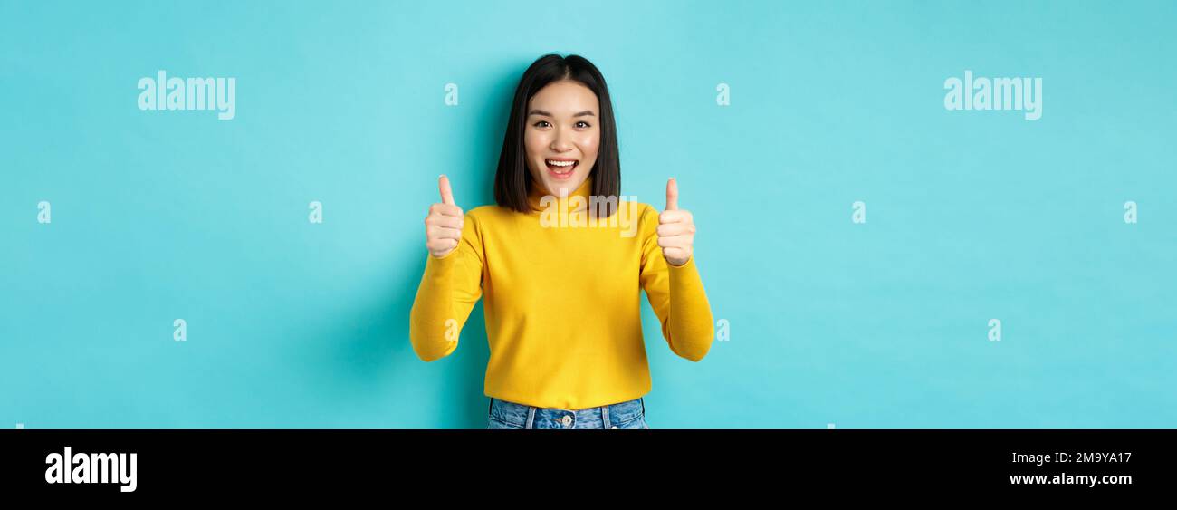 Beautiful asian woman praise good work, showing thumbs up gesture and ...
