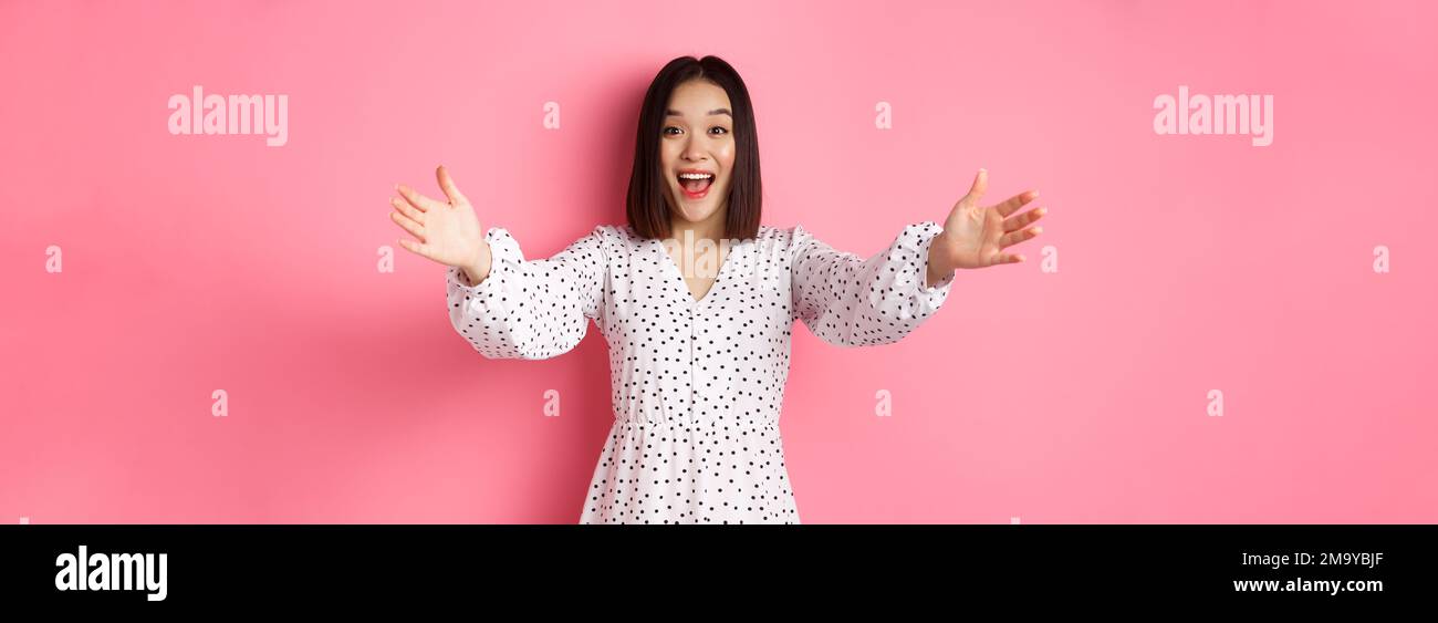 Happy asian girl stretching hands to camera, reaching for hug, smiling ...