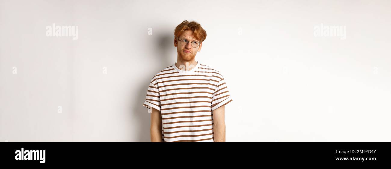 Sad and gloomy redhead man looking upper left corner, sulking and ...