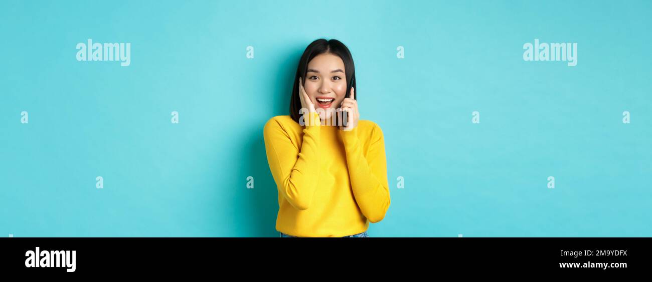 Happy asian woman receive offer on phone call, smiling while talking on ...