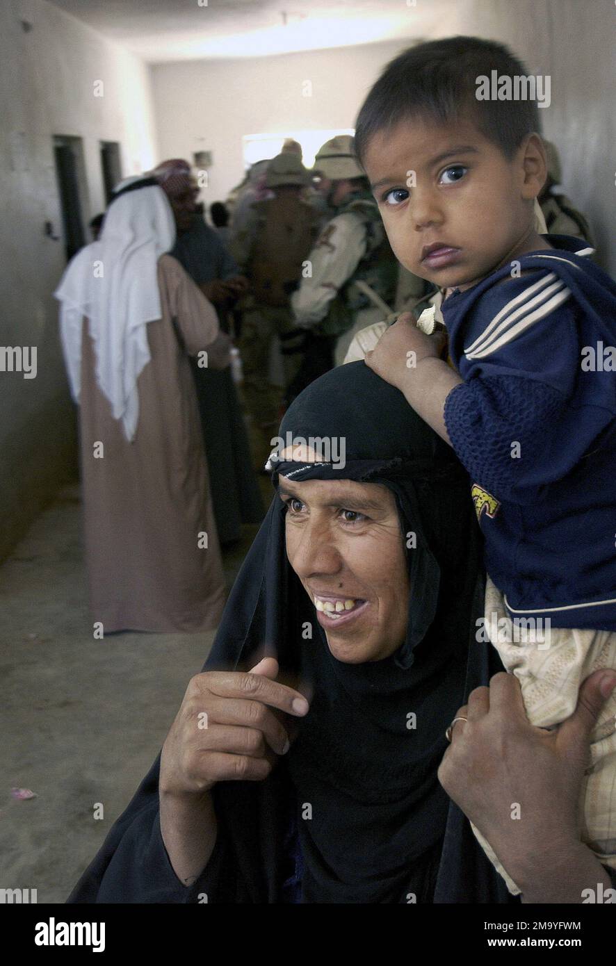 An Iraqi woman and her baby smile at the donations from students at ...