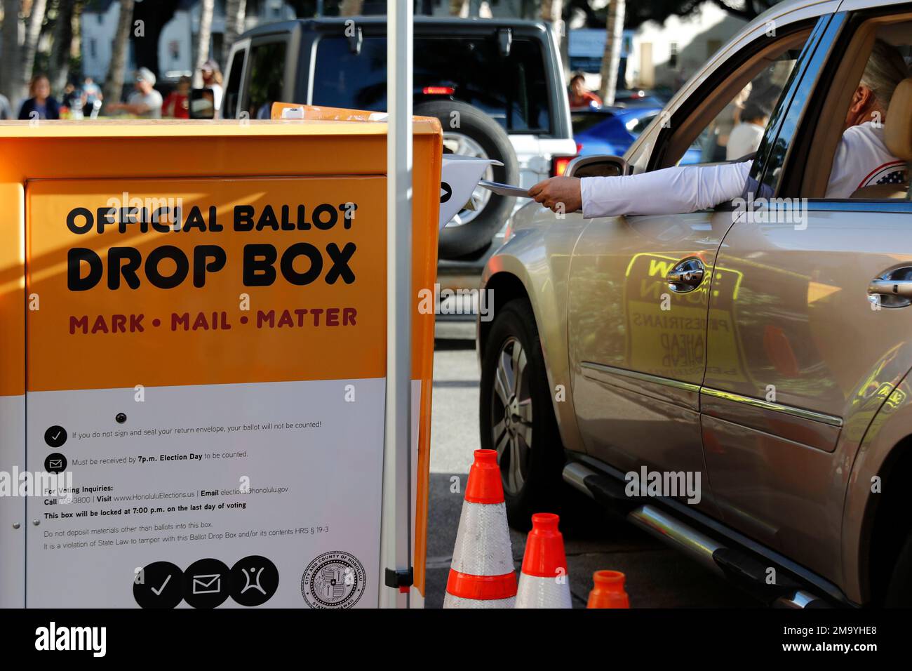 A driver slides a ballot into a voting drop box location, Tuesday, Nov ...