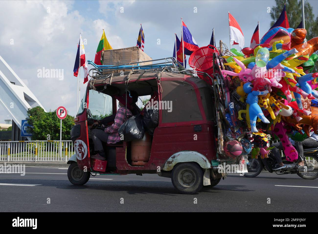 A motorized rickshaw drives past the Association of Southeast Asian ...