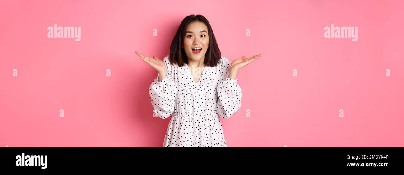 Image of surprised korean girl in dress, female model staring at camera ...