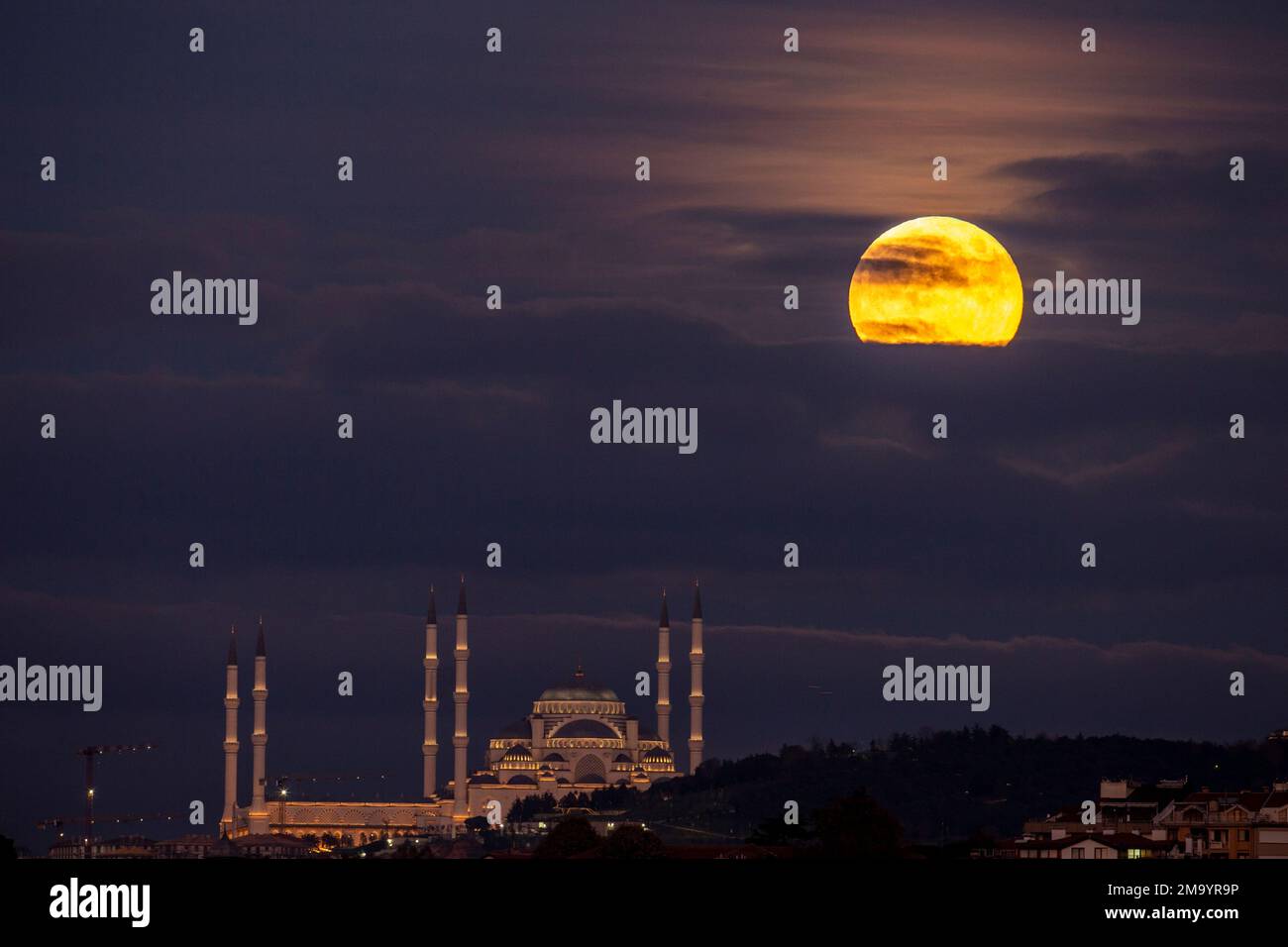 A full moon rises behind the Camlica mosque in Istanbul, Turkey ...