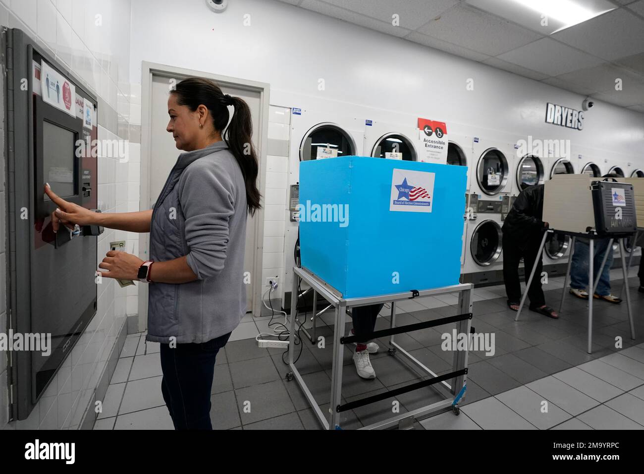 Stella Lopez puts cash on a laundry card at the Su Nueva Lavanderia ...