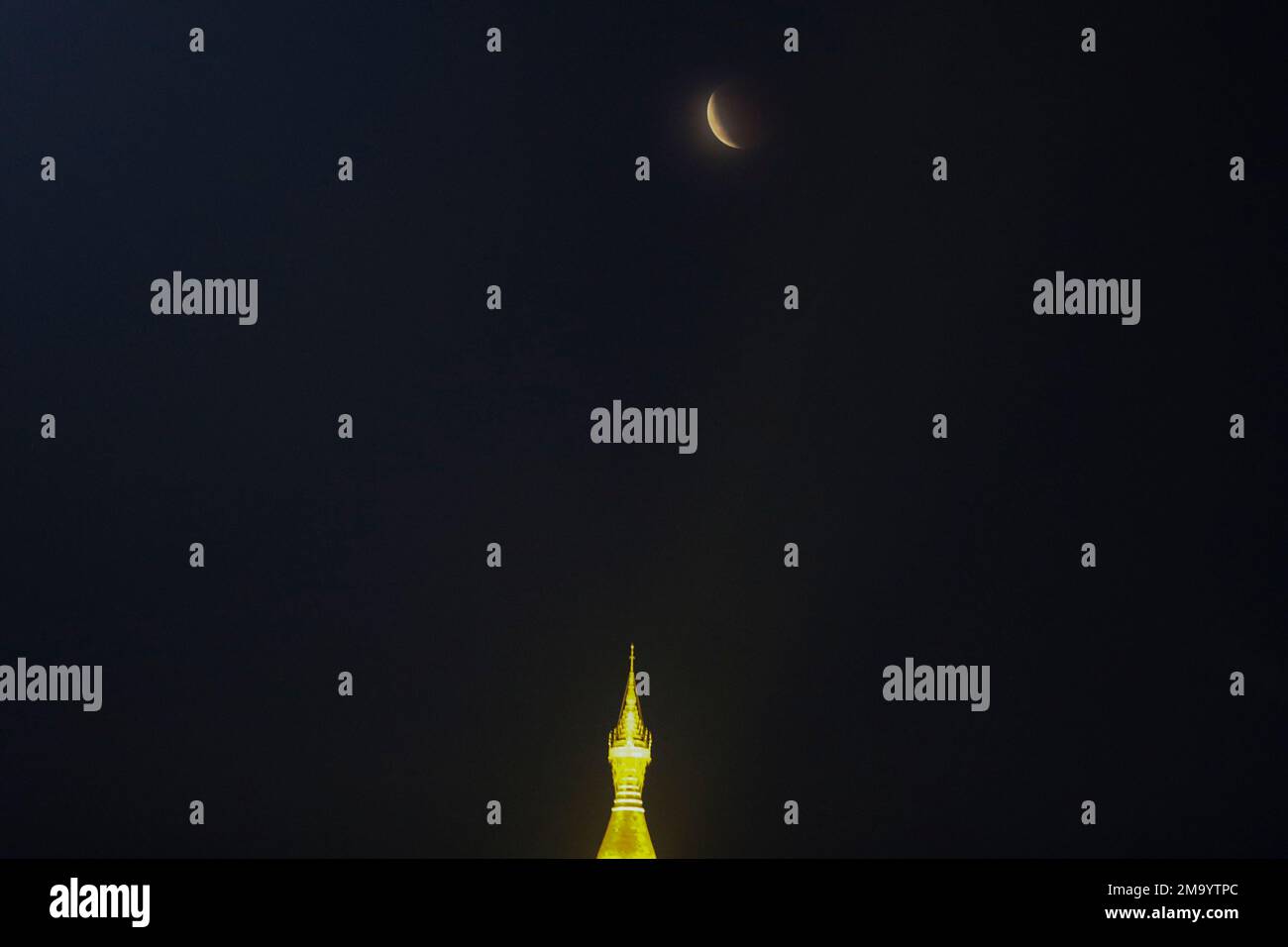 The moon rises above Myanmar Landmark Shwedagon pagoda during a lunar eclipse in Yangon, Myanmar ...