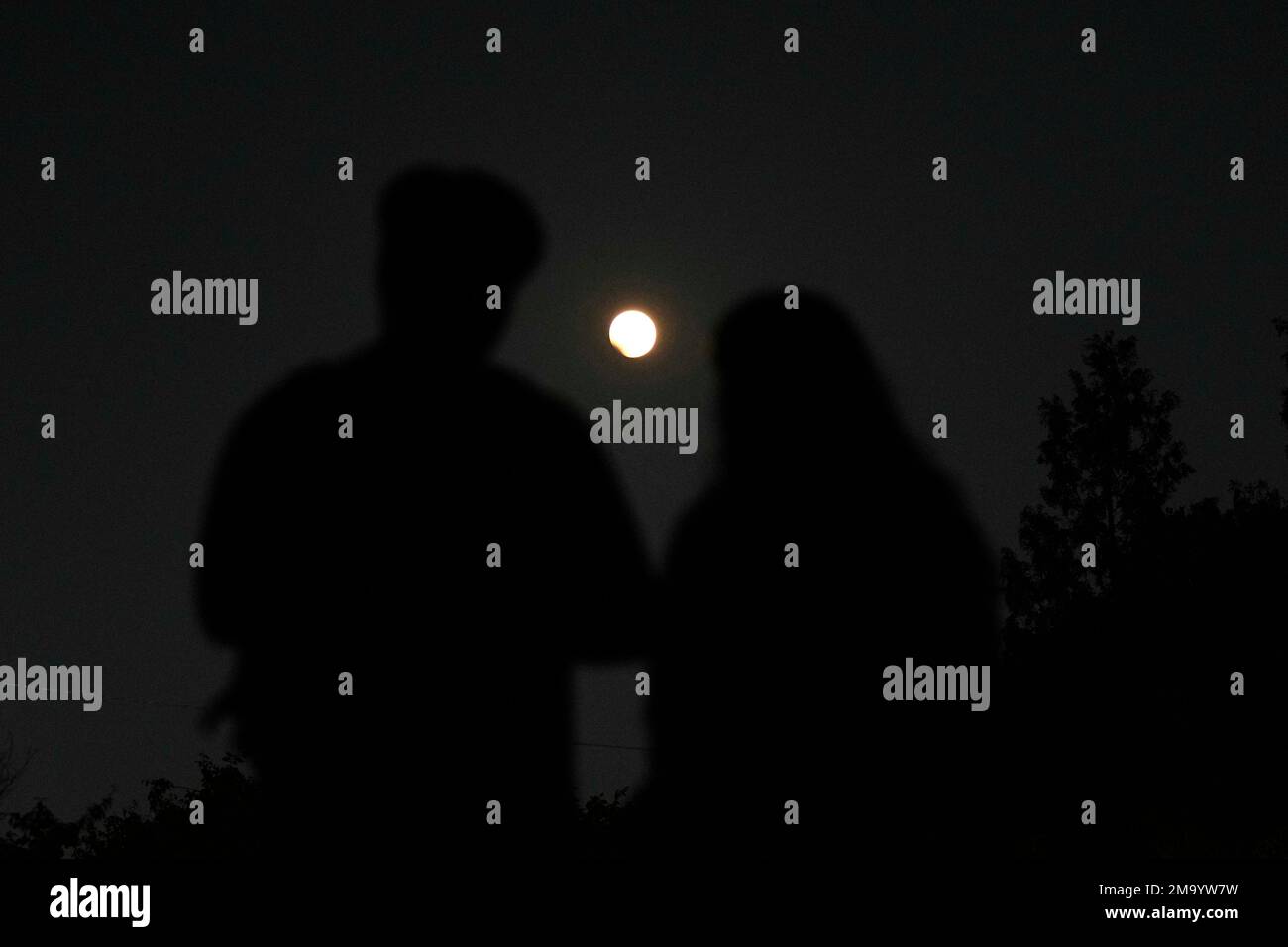 The earth's shadow starts to cover the moon during a lunar eclipse in Seoul, South Korea ...