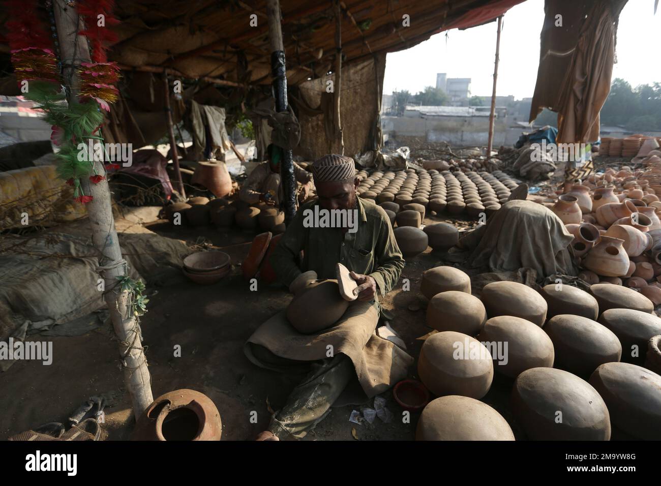 A potter makes a clay pot at his workshop in Karachi, Pakistan, Tuesday ...