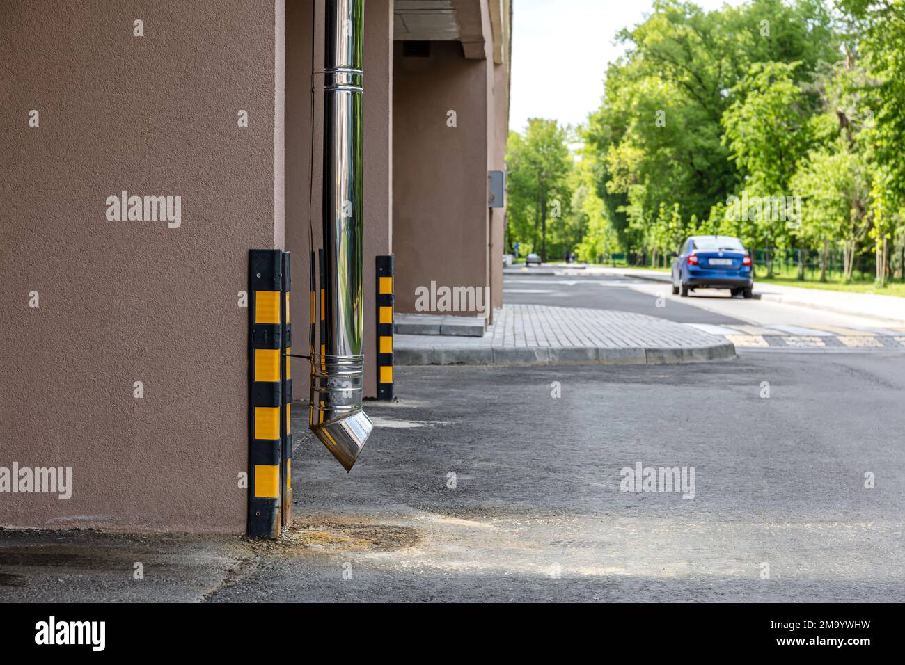 blue car parked on the roadside near residential building at sunny ...