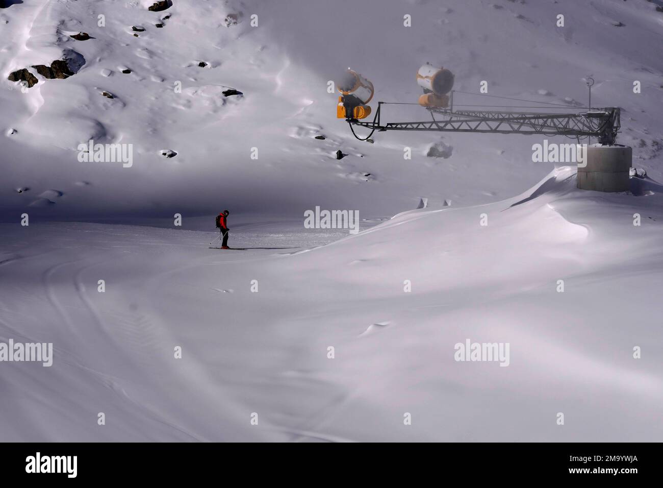 A skier passes an artificial snow maker as he speeds down the track at ...