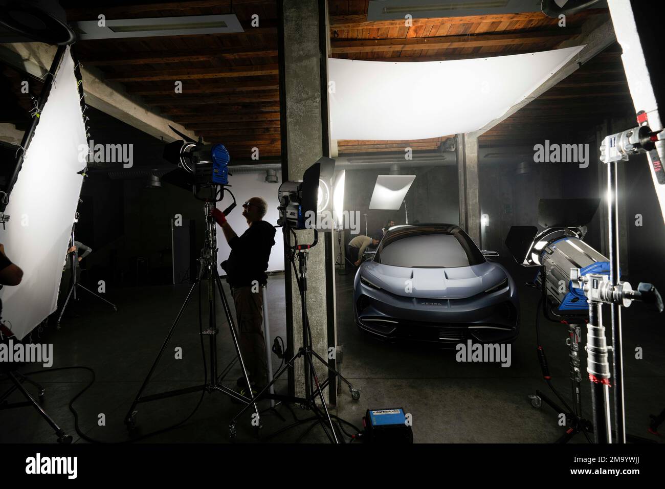 A photo assistant prepares lighting for a photo shoot of the Aehra new ...
