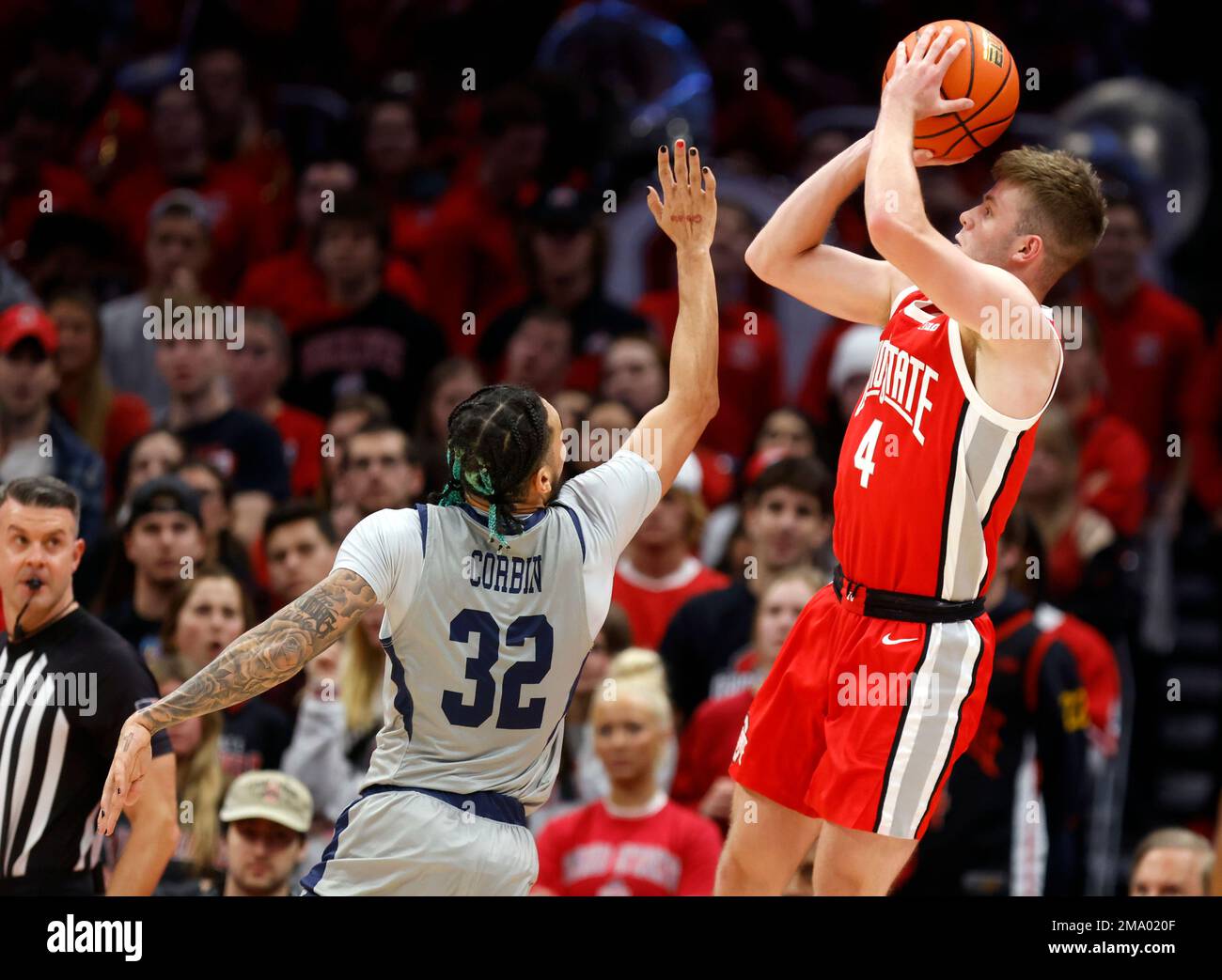 Ohio State guard Sean McNeil, right, goes up for a shot in front of ...