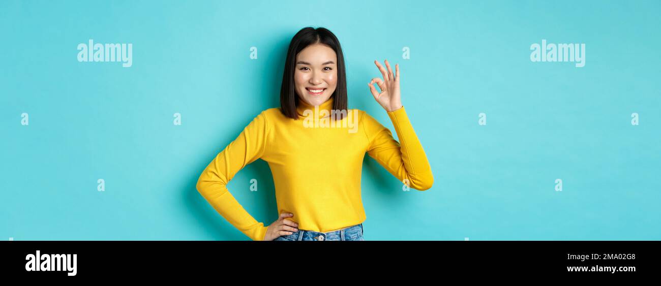 Happy beautiful asian woman smiling, showing okay gesture in approval ...