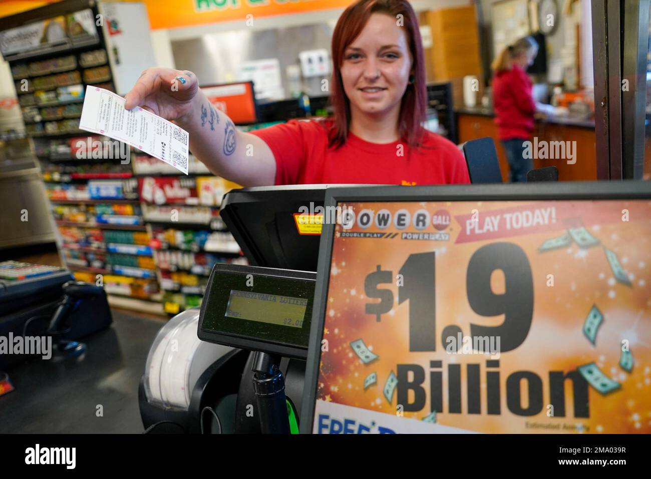 Crystal Baptiste hands a ticket to a customer for the Monday Powerball ...