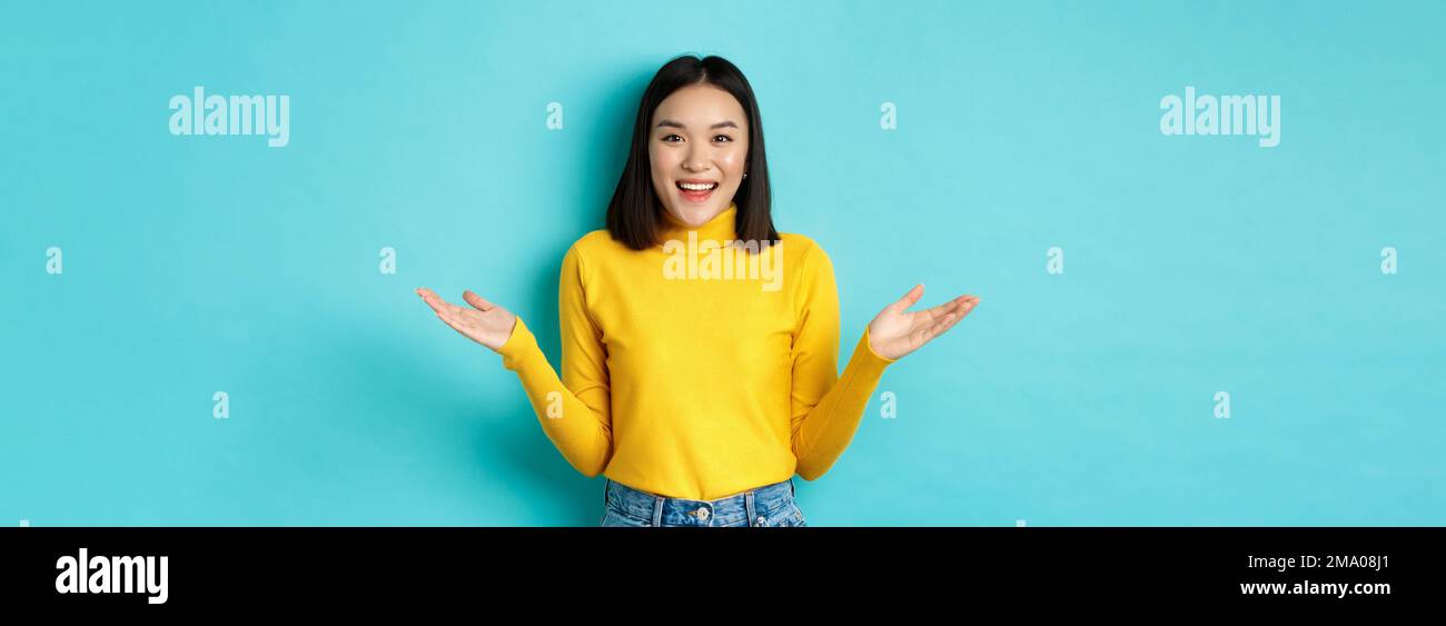 Portrait of happy attractive woman spread hands sideways and smiling ...