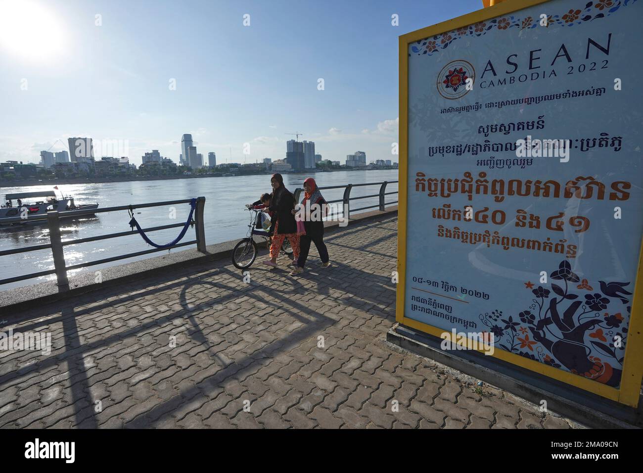 Muslim villagers walk alongside the Tonle Sap river past an Association ...