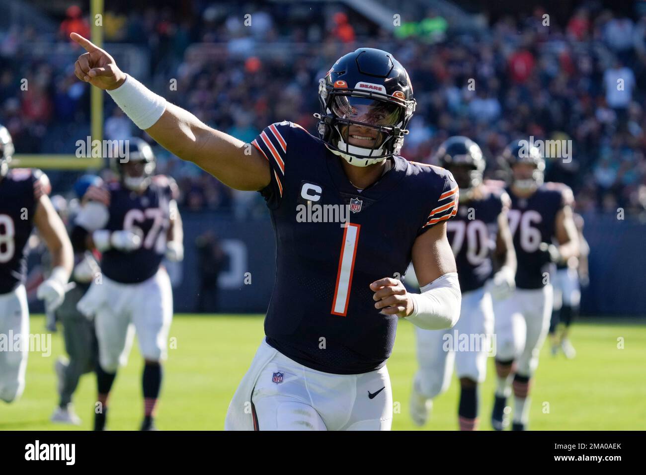 Chicago Bears quarterback Justin Fields points as he runs to the locker ...
