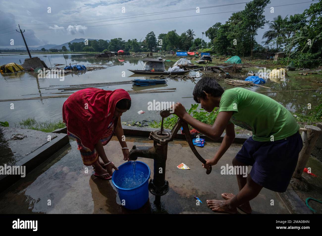 The wife of Ranajit Mandal, a priest of a temple that was washed away, collects drinking water ...