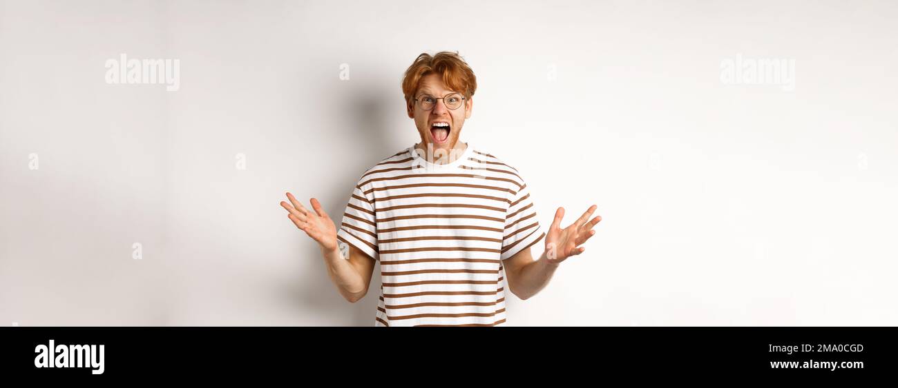 Frustrated man with red hair shaking hands and yelling at camera ...