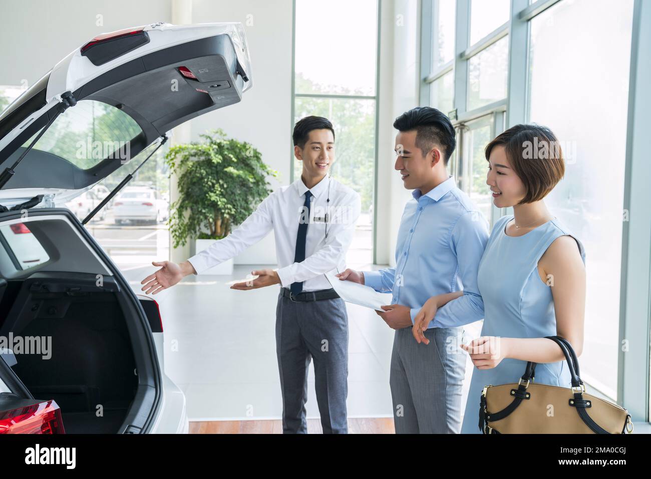 Young people in the car 4 s shop Stock Photo - Alamy