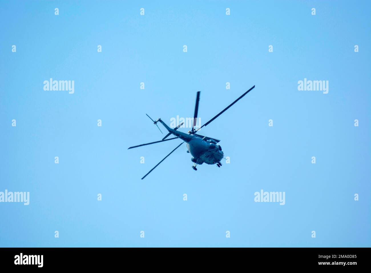 Helicopters are flying in isolated blue sky. combat helicopter turning ...
