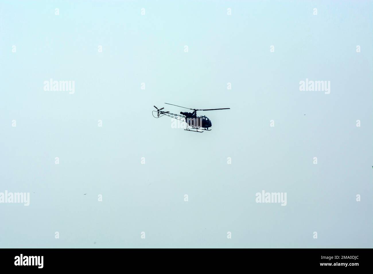 Combat helicopter is flying against isolated blue sky. Combat ...