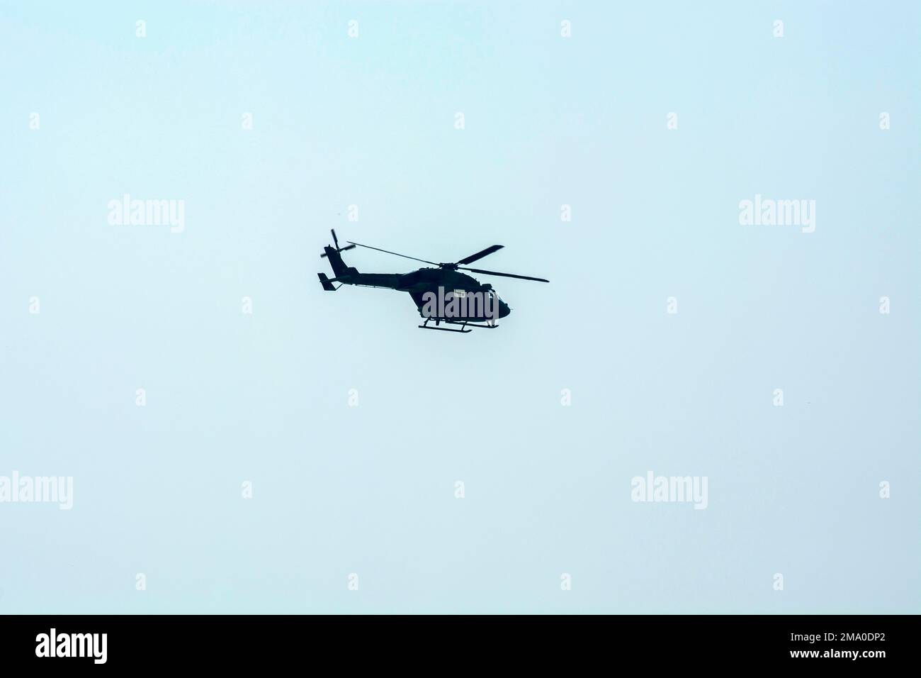 Combat helicopter is flying against isolated blue sky. Combat ...