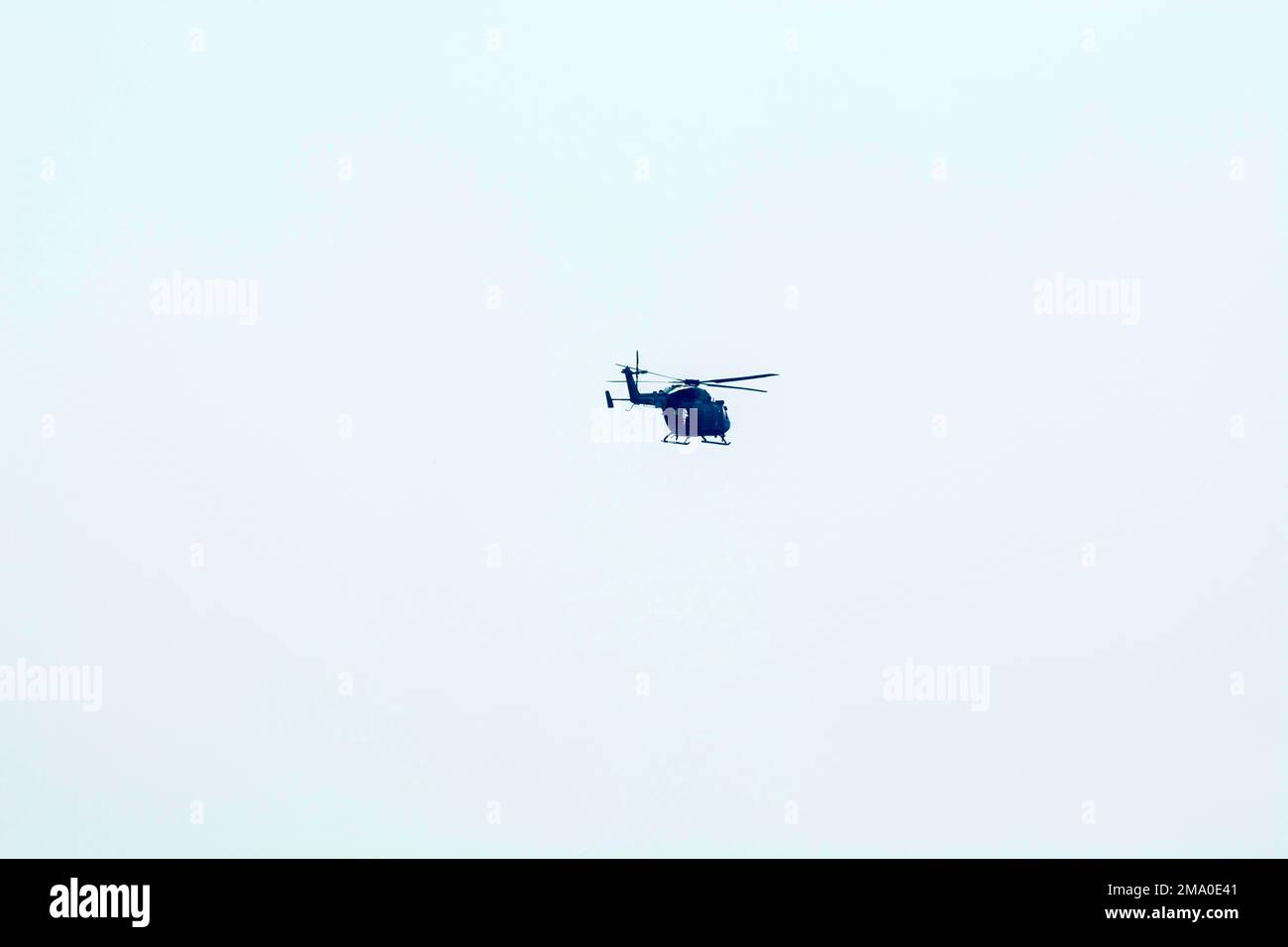 Combat helicopter is flying against isolated blue sky. Combat ...