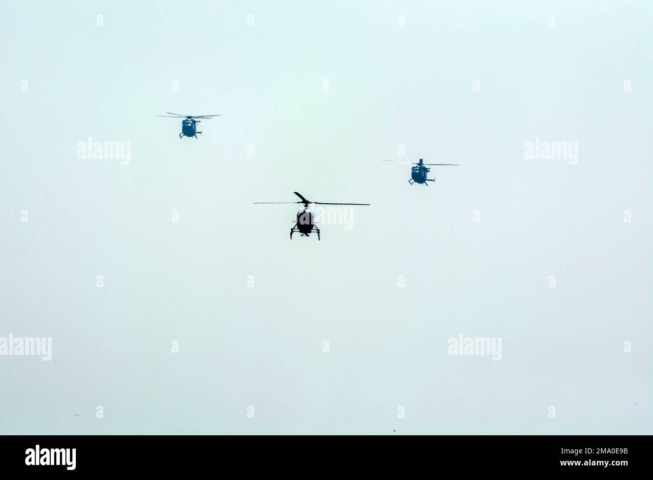 Three military helicopters flying on sky in Arrow head formation ...