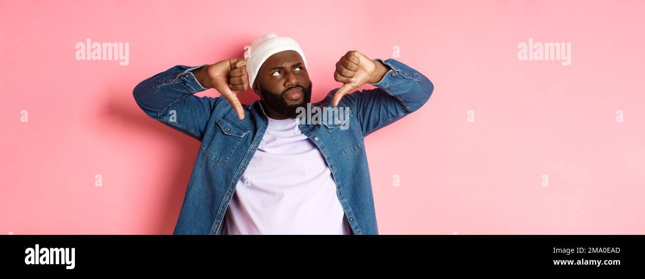 Disappointed Black man staring at upper left corner annoyed, showing ...