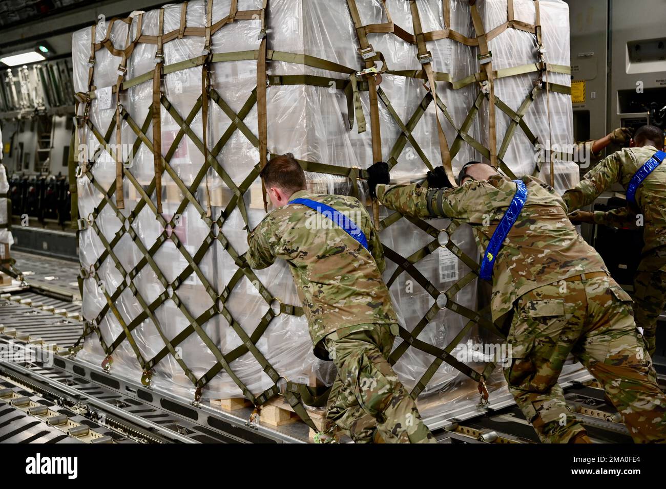 U.S. Air Force Airmen assigned to the 721st Aerial Port Squadron push a ...