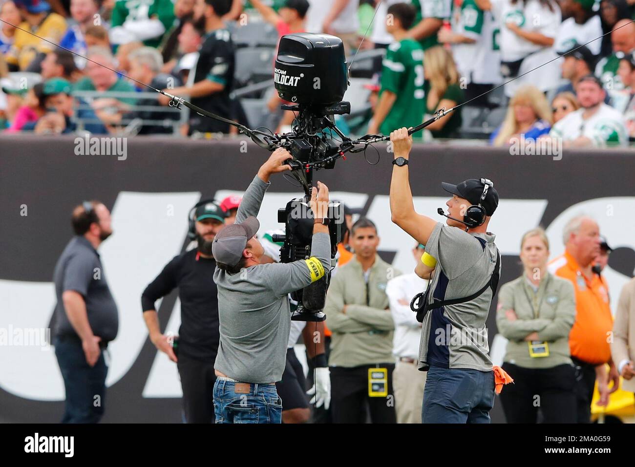 Workers repair a remote camera during a delay during the second half of ...