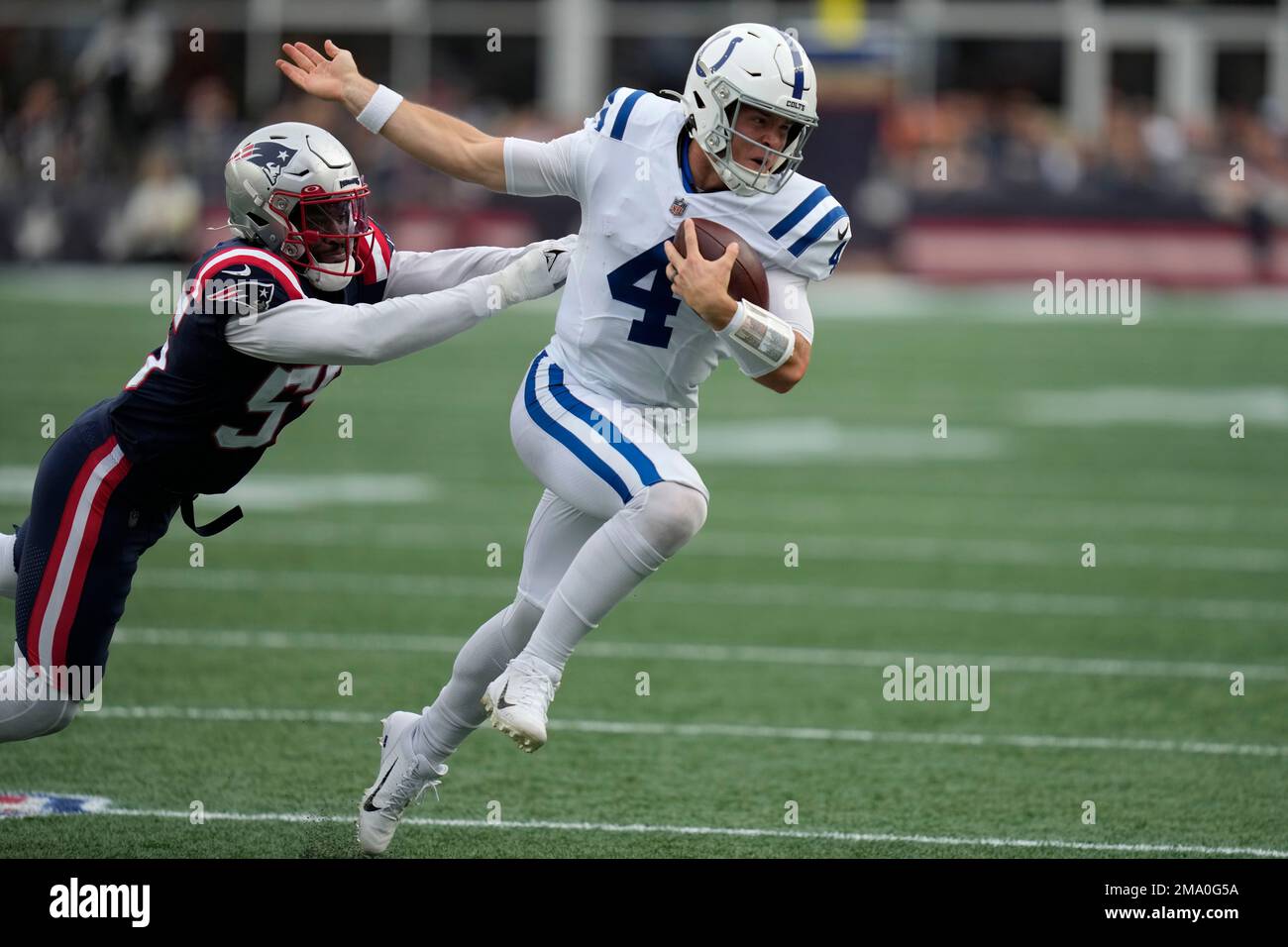 New England Patriots linebacker Josh Uche, left, brings down ...