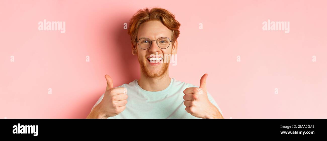 Face of satisfied male customer showing thumbs-up in approval, smiling ...