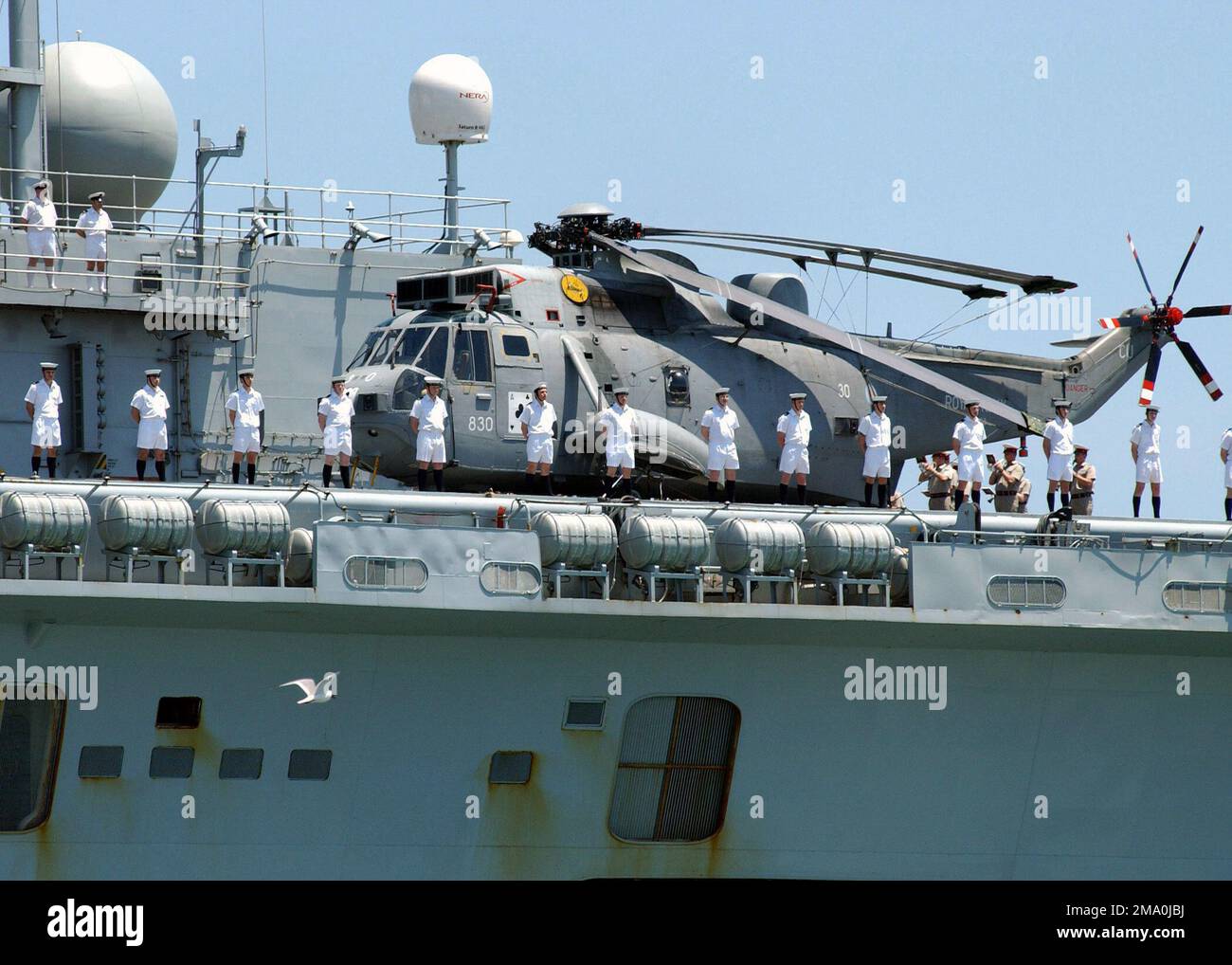 Royal Navy (RN) Sailors line the rails of the RN Aircraft Carrier, Her ...