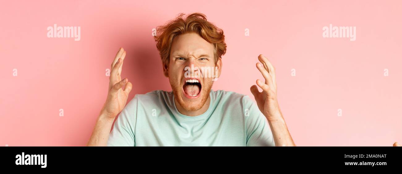 Face of angry redhead man shouting and shaking hands furious, staring ...