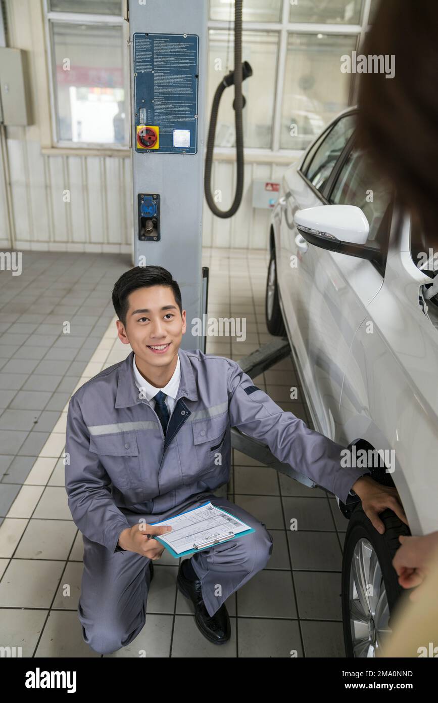Repair shop mechanics of personnel with the customer Stock Photo - Alamy