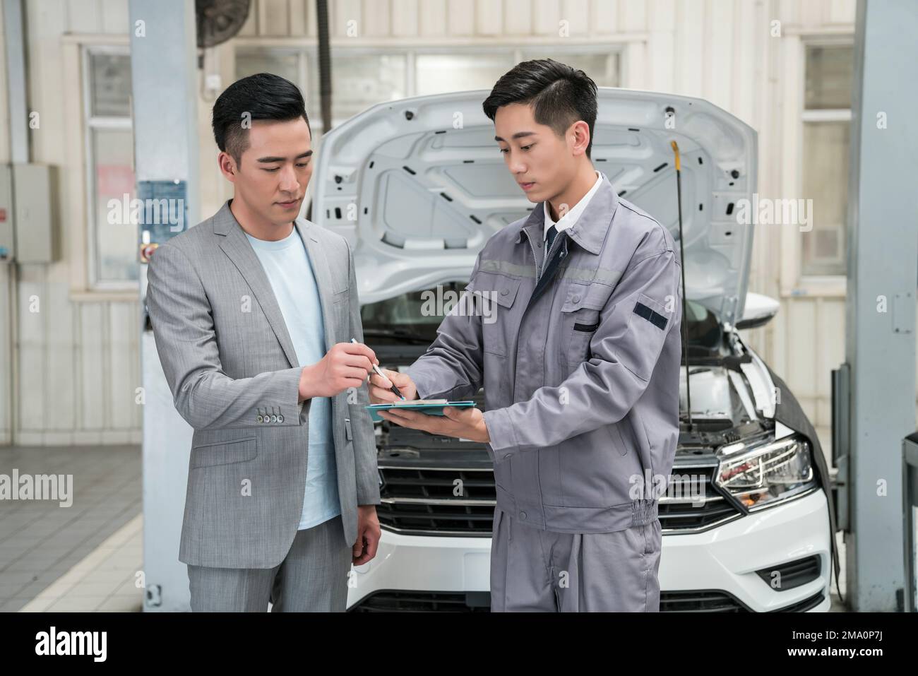 Repair shop mechanics of personnel with the customer Stock Photo - Alamy