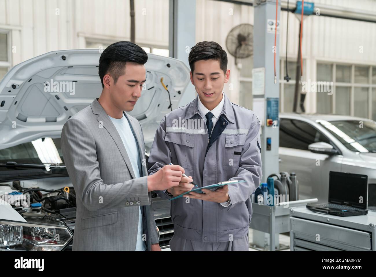 Repair shop mechanics of personnel with the customer Stock Photo - Alamy